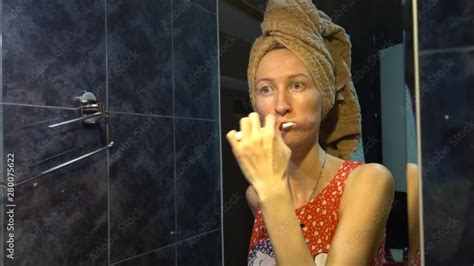 Beautiful Woman Brushing Her Teeth In A Modern Bathroom A Woman