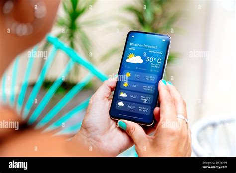 Woman Outdoors Checking The Weather Forecast On An App On Her Mobile