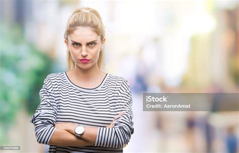 젊은 아름 다운 금발 여자 고립 된 배경 회의론과 긴장에 줄무늬 스웨터를 입고 교차 팔과 얼굴에 표현을 거부 부정적인 사람 감정에 대한 스톡 사진 및 기타 이미지 Istock