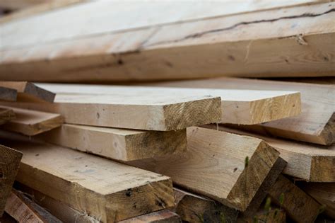 자연 갈색 고르지 못한 거친 나무 보드의 밝은 태양에 의해 점화 쌓여 스택의 클로즈업 목공 건축 수리 및 가구 건설에 대 한