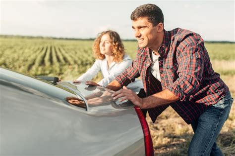 Hombre Y Mujer Empujar Un Coche Roto Vista Trasera Foto Premium