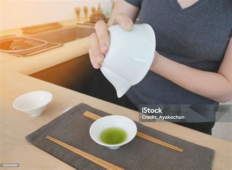회색에 흰색 작은 세라믹 컵 여성 붓는 녹차 홍차가 게에서 매트 옷 젓가락은 또한 요리를 먹고 다음 녹차 잎에 대 한 준비 배치