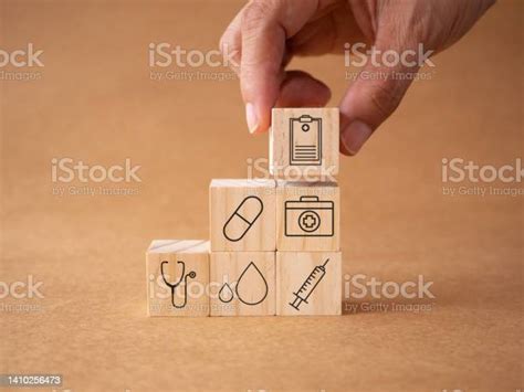 개념 연간 건강 검진 갈색 배경에 의료 아이콘 보고서 혈액 주사기 청진기 및 심장 박동이있는 나무 큐브를 들고있는 손 갈색에