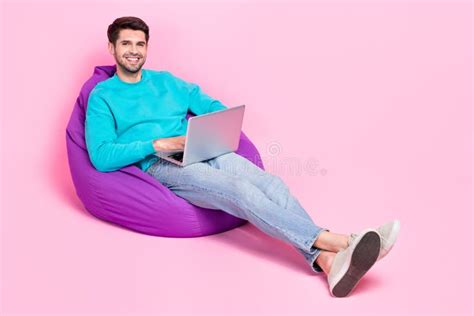 Full Length Photo Of Handsome Young Guy Sit Bean Bag Working Remotely Coder Wear Trendy Blue