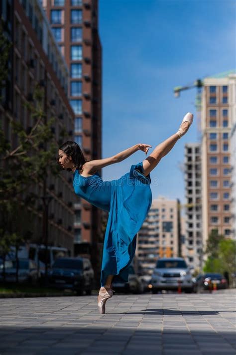 Beautiful Asian Ballerina In Blue Dress Posing In Splits Outdoors Urban Landscape Vertical