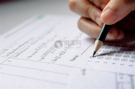 学生手持铅笔在答题纸和数学问题纸上书写选定的选项学生测试做考高清图片下载 正版图片504187330 摄图网