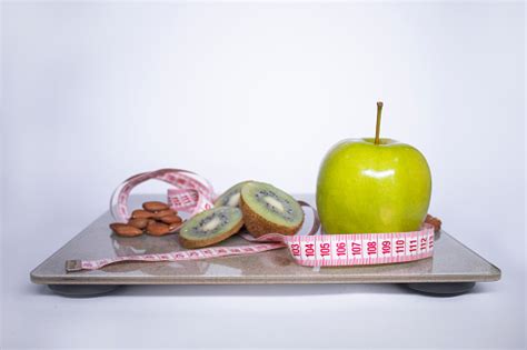 베이지 색 욕실 비늘에 빨간 측정 테이프 사과 키위와 아몬드 다이어트와 건강한 삶 체중 감량 스포츠 컨셉 공간을 복사합니다 격리 흰색 배경 가냘픈에 대한 스톡 사진 및 기타