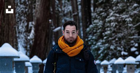 검은 재킷을 입고 노란 스카프를 두른 여자가 낮에 눈 덮인 땅에 서 있다 사진 Unsplash의 무료 일본 이미지