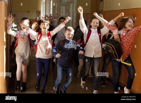 Happy Pupils Running Out Of The Classroom On Summer Vacation Stock