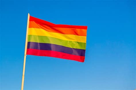 Símbolo do movimento lgbt da bandeira do arco íris contra o fundo do céu azul Foto Premium