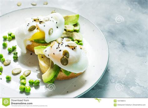 Delicious Poached Egg With Bread And Sliced Avocado On Concrete