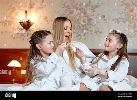 The Smiling Twin Girls Feed Mother With The Breakfast They Laugh Sit