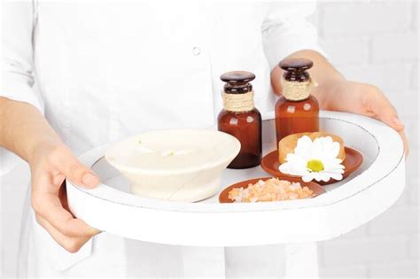 Premium Photo Beauty Therapist Holding Tray Of Spa Treatments Closeup