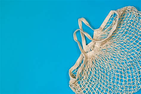 배달용 스트링 백 파란색 배경에 빈 재사용 가능한 에코 쇼핑백 제로 폐기물 개념 맨 위 보기입니다 공간을 복사합니다 0에 대한