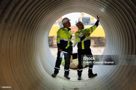 남녀 엔지니어가 대형 강관 내부를 검사합니다 작업자들은 산업 플랜트에서 석유 천연 가스 및 연료를 운송하기 위한 파이프라인을