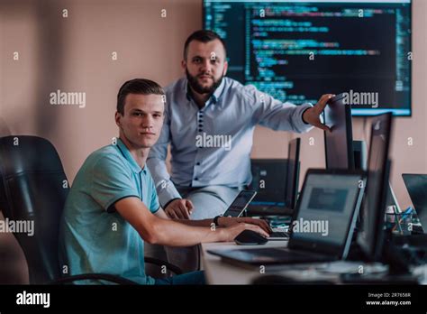 Programmers Engrossed In Deep Collaboration Diligently Working Together To Solve Complex