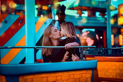 놀이 공원에서 행복한 어머니는 그녀의 소중한 어린 아이 승마 놀이기구를 키스 행복한 여름 주말 가족 사랑 개념 놀이 공원에서 행복한 가족 사진 배경 및 무료 다운로드를위한