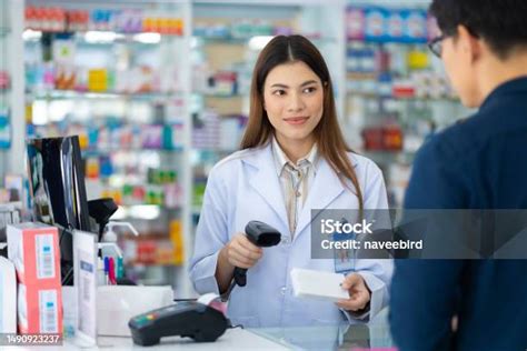 아시아 여성 약사가 약국에서 바코드 판독기 스캔 알약 상자를 들고 있다 의약품 및 건강 관리 제품이있는 선반 건강관리와 의술에 대한 스톡 사진 및 기타 이미지 Istock