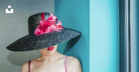 분홍색 캐미탑과 검은 밀짚 모자를 쓰고 있는 여자 사진 Unsplash의 무료 모자 이미지