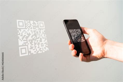 Hand Holding A Smartphone And Scan The Qr Code To Make A Payment Stock Photo Adobe Stock