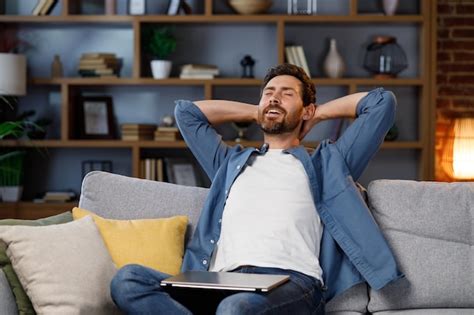 Premium Photo Handsome Man Working On Laptop While Sitting On Sofa In