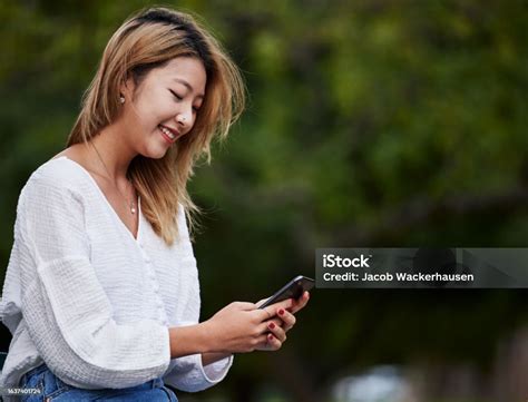 행복한 여자 모형과 정원에서 전화로 타이핑 이메일 소셜 미디어 밈 또는 텍스트 읽기 핸드폰 인터넷 검색 공원 공간에서 아시아