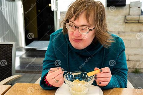 Portrait Of A Happy 40 Yo Woman With Down Syndrome Eating An Ice Cream