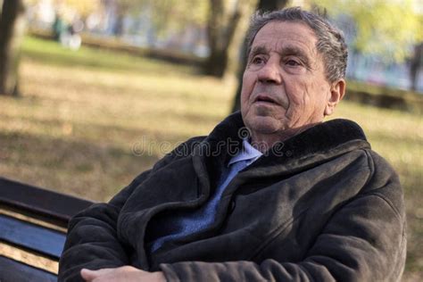 Un Anciano Solitario Sentado En Un Banco Foto De Archivo Imagen De