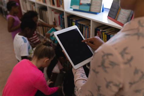 Guru Perempuan Yang Bekerja Pada Tablet Digital Di Perpustakaan Sekolah