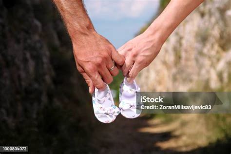 임신한 여자와 남자 아기 신발을 손에 들고 미래 엄마와 아빠 부모는 작은 신생아 신발 들고 있다 출생 기대 개념입니다 아기의 대기 임신 임신 어머니입니다 2명에 대한 스톡