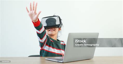 홈 안경의 책상에 앉아 Vr을 입은 어린 소녀는 가상 글로벌 인터넷 연결 메타버스 게임을 위한 Vr 헤드셋을 착용한 흰색 옷을 입은 미래의 아이들 개념 고급 기술 6 7