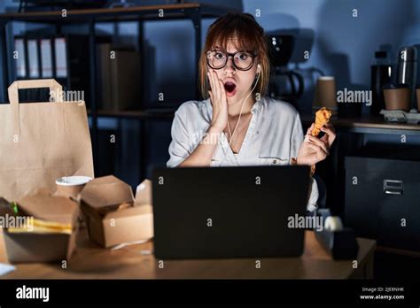 Young Beautiful Woman Working Using Computer Laptop And Eating Delivery Food Afraid And Shocked