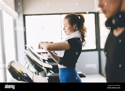 People Running On A Treadmill In Health Club Using Smart Watch Tracking