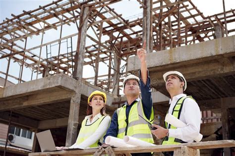 Asian Architector And Engineers Team With Draft Plan Of Building And
