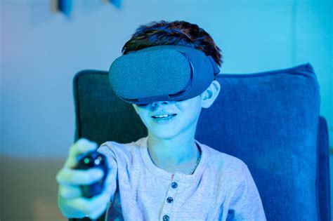 네온 라이트 효과와 함께 보여주는 소파에 앉아있는 동안 Vr 또는 가상 현실 헤드셋과 게임 패드를 착용하여 게임을 하는 어린