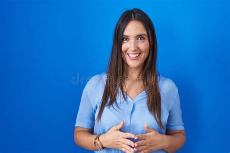 Young Brunette Woman Standing Over Blue Background Hands Together And