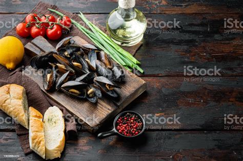 마늘 소스에 삶은 홍합과 파슬리와 재료 나무 도마 오래된 어두운 나무 테이블 배경 카피 스페이스와 텍스트 공간 갑각류에 대한