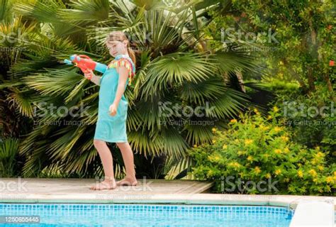 Gadis Muda Menggemaskan Bermain Dengan Pistol Airnya Foto Stok Unduh