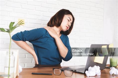 사무실 증후군을 앓고 있는 아시아 여성 사업가가 사무실 책상에 앉아 몸 목 어깨 통증을 스트레칭합니다 45 49세에 대한 스톡