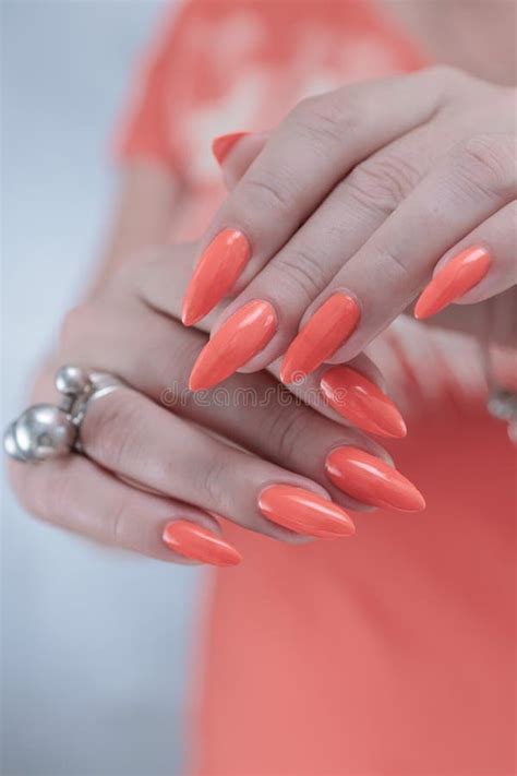 Female Hands With Long Nails And Neon Coral Orange Nail Polish Stock