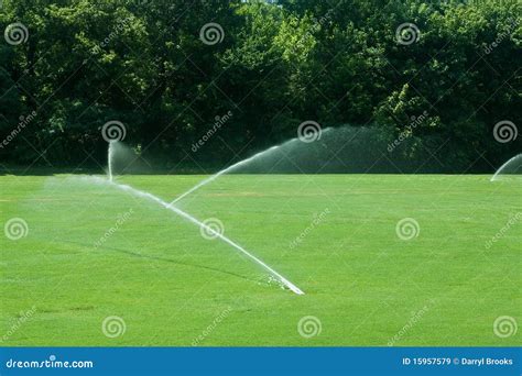 Sprinklers Irrigating A Green Grass Field Stock Image Image Of