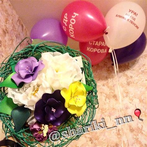 some balloons and flowers in a green basket