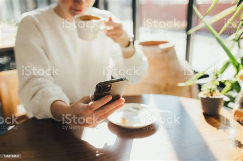 스마트폰을 사용하고 카페에서 향기로운 커피를 마시는 여자 25 29세에 대한 스톡 사진 및 기타 이미지 25 29세 단일