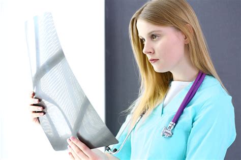 의사 여자 외과 의사 진료소 또는 병원에 창문 가까이 서 있는 동안 X 선 사진 검사 의학 및 건강 관리 개념입니다 직장에서