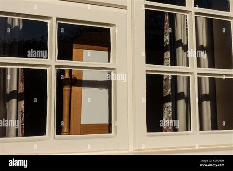 Cream Window Frame With Rear Of Mirror And Curtains Through Glass Stock