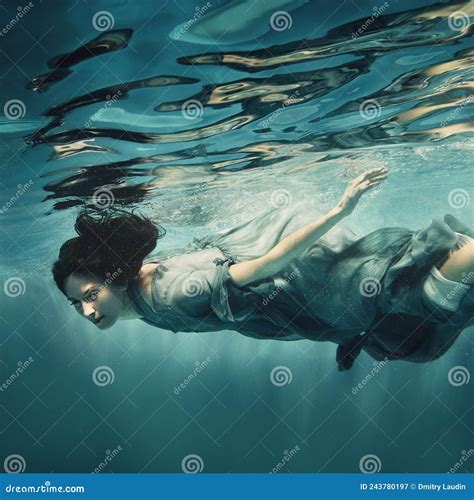 A Woman In A Dress Swims Underwater As If Floating In Zero Gravity
