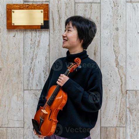 Young Chinese Female Violin Maker Showing Her Freshly Made Violin