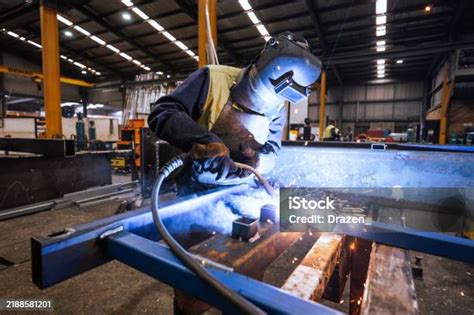 보호 장구를 착용한 작업자가 산업 공장 환경에서 금속을 용접하고 있으며 불꽃이 주변을 휘날리며 해당 지역을 밝게 비추고 있습니다 용접공에 대한 스톡 사진 및 기타 이미지