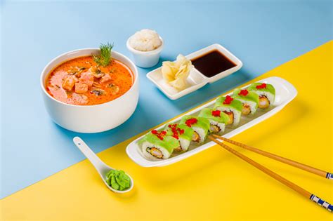 연어를 곁들인 톰 얌 수프와 파란색 노란색 배경에 아보카도와 새우 튀김을 곁들인 롤 초밥에 대한 스톡 사진 및 기타 이미지 초밥 고수 수프 Istock