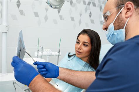 사람 의학 Stomatology 및 건강 관리 개념 치과 진료소 사무실에서 여성 환자에게 작업 계획을 보여주는 행복한 남성 치과